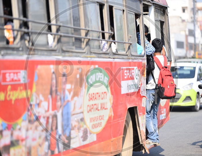 Image of Students travelling on foot board in Bus-BO449426-Picxy