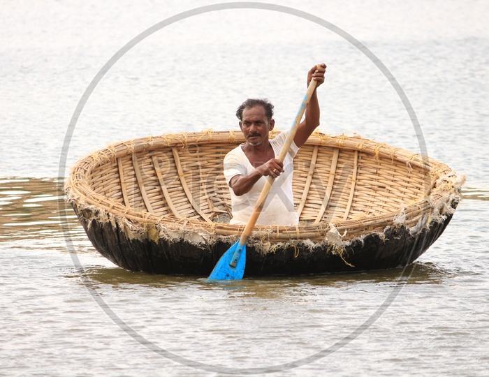 Image of man sailing in coracle boat in hampi-UZ453929-Picxy