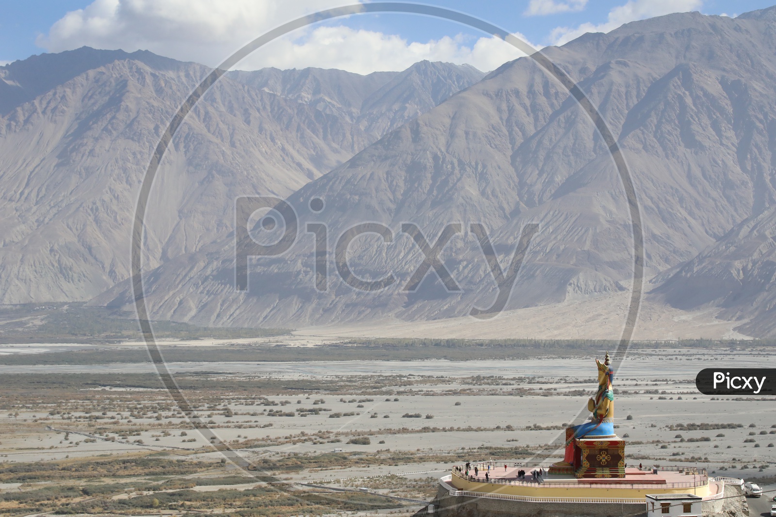 Image of Statue of Buddha in leh with snow capped mountains in the ...