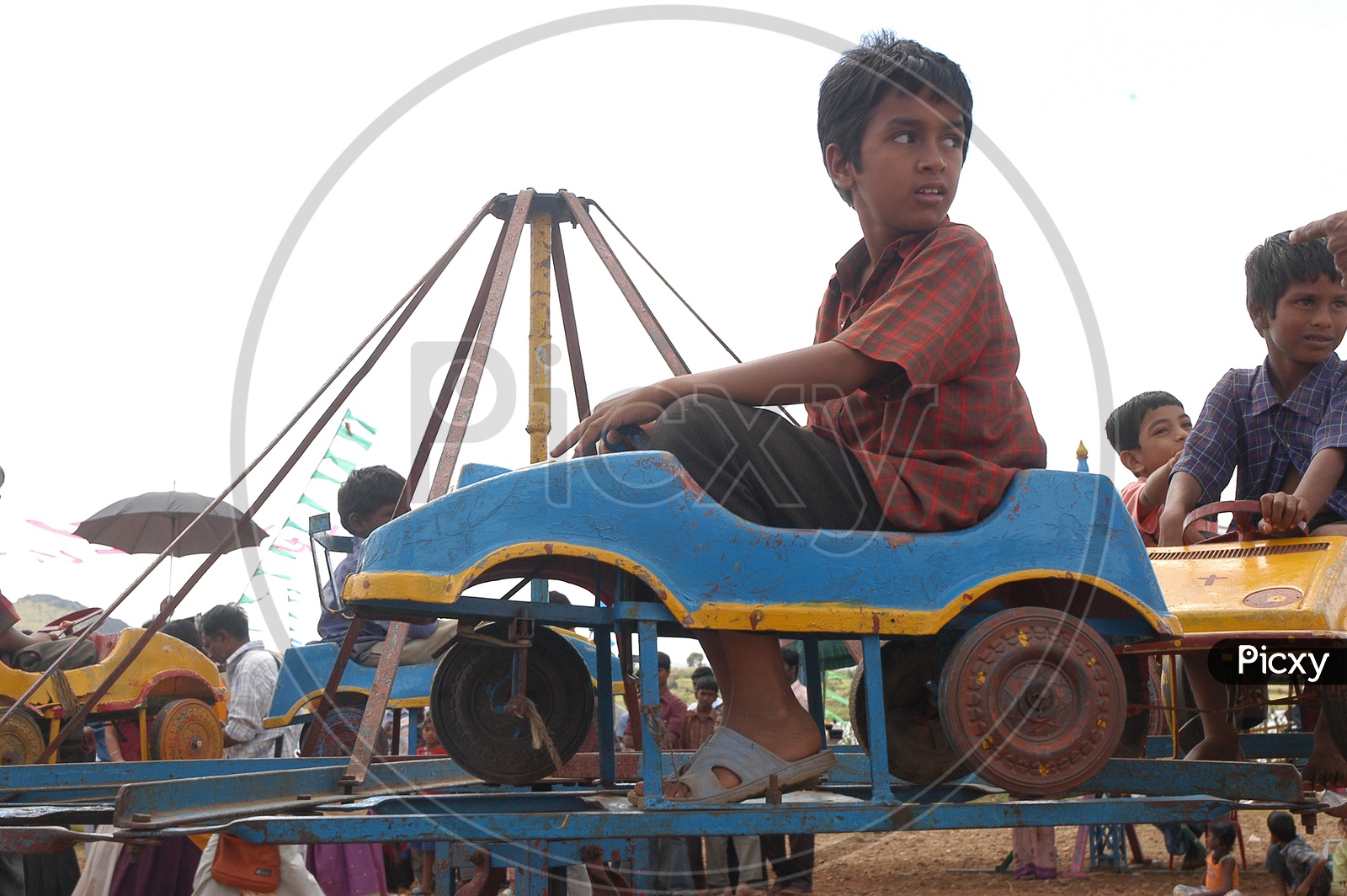 Image of Indian Kid/boy on a toy car-TI694352-Picxy