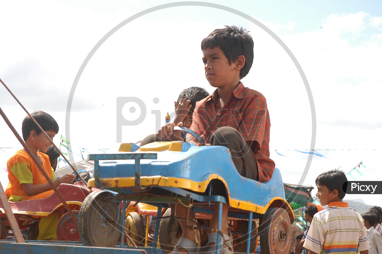 Image of Indian Kid/boy on a toy car-BJ096132-Picxy