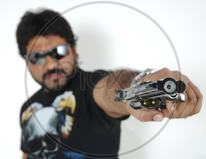 Image of Telugu/Tamil/South Indian actor holding a gun. Behind the ...