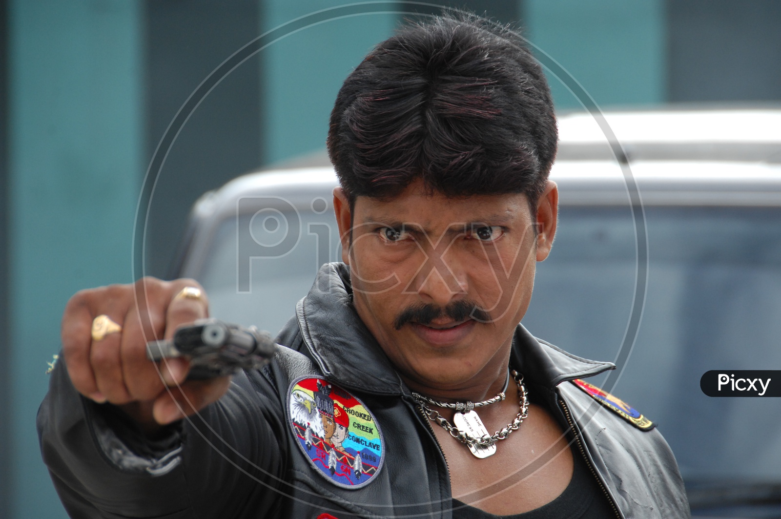 Image of Telugu/Tamil/South Indian actor holding a gun. Behind the ...