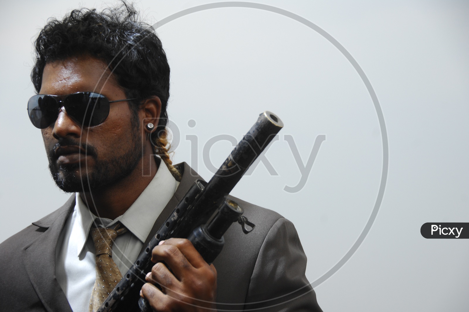 Image of Telugu/Tamil/South Indian actor holding a gun. Behind the ...