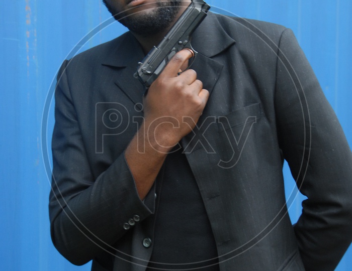 Image of African origin actor holding a gun. Behind the scenes or the ...