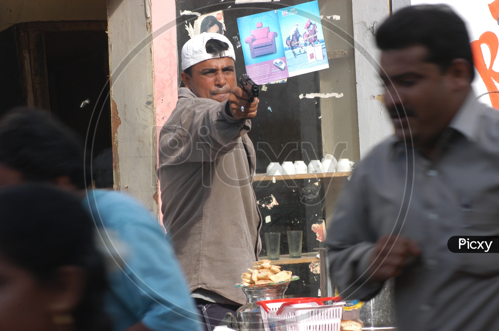Image of Telugu/Tamil/South Indian actor holding a gun. Behind the ...