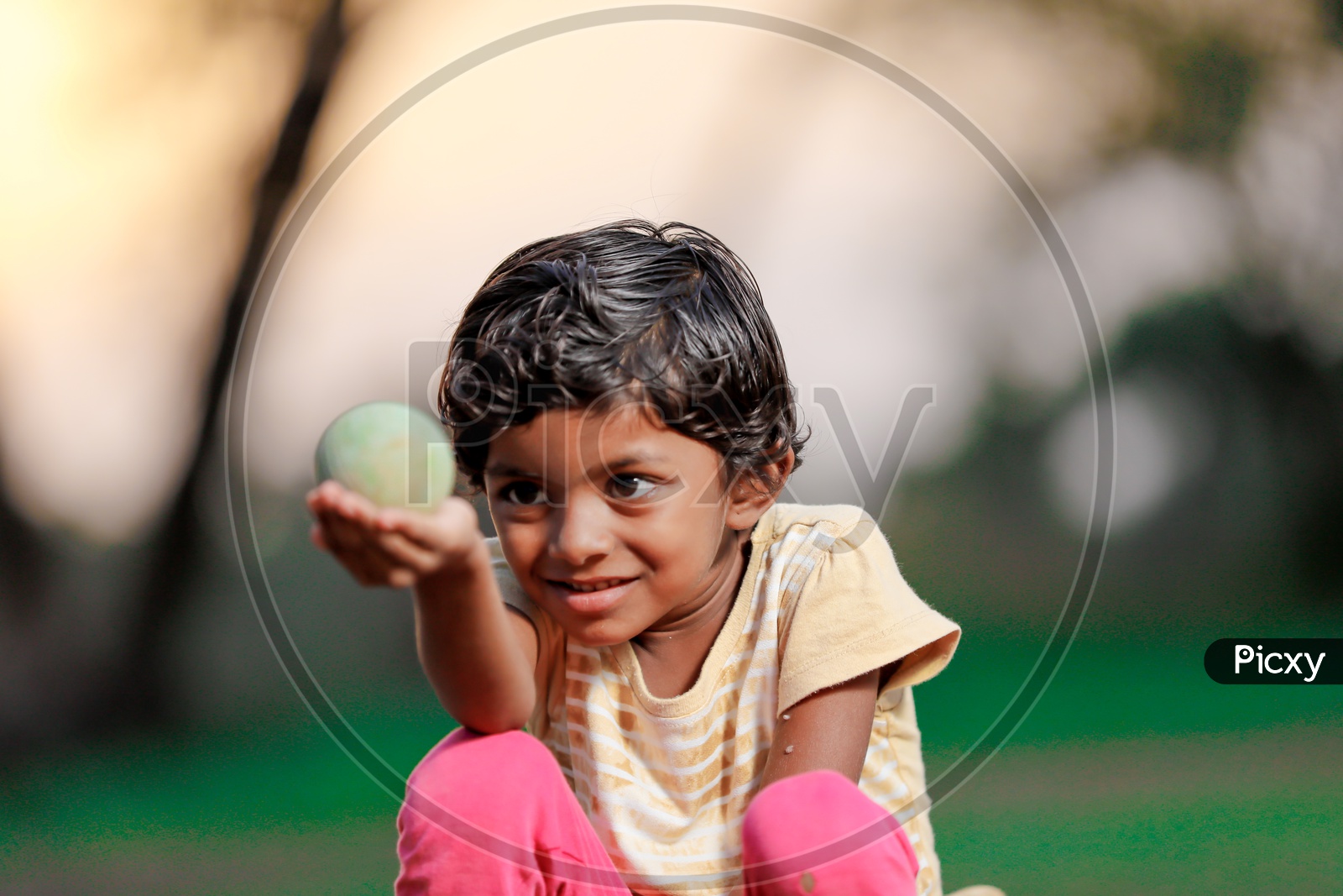 Image of Indian Girl Child Playing with a Cricket ball-ME385901-Picxy