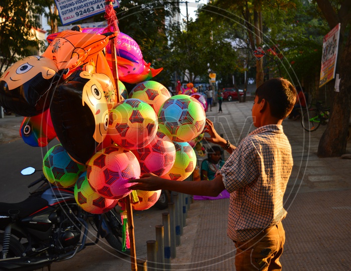 Image of A Small Boy vendor Selling toys on a Road-OH523125-Picxy