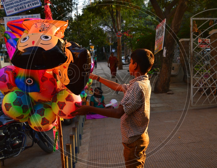 Image of A Small Boy vendor Selling toys on a Road-YO505164-Picxy