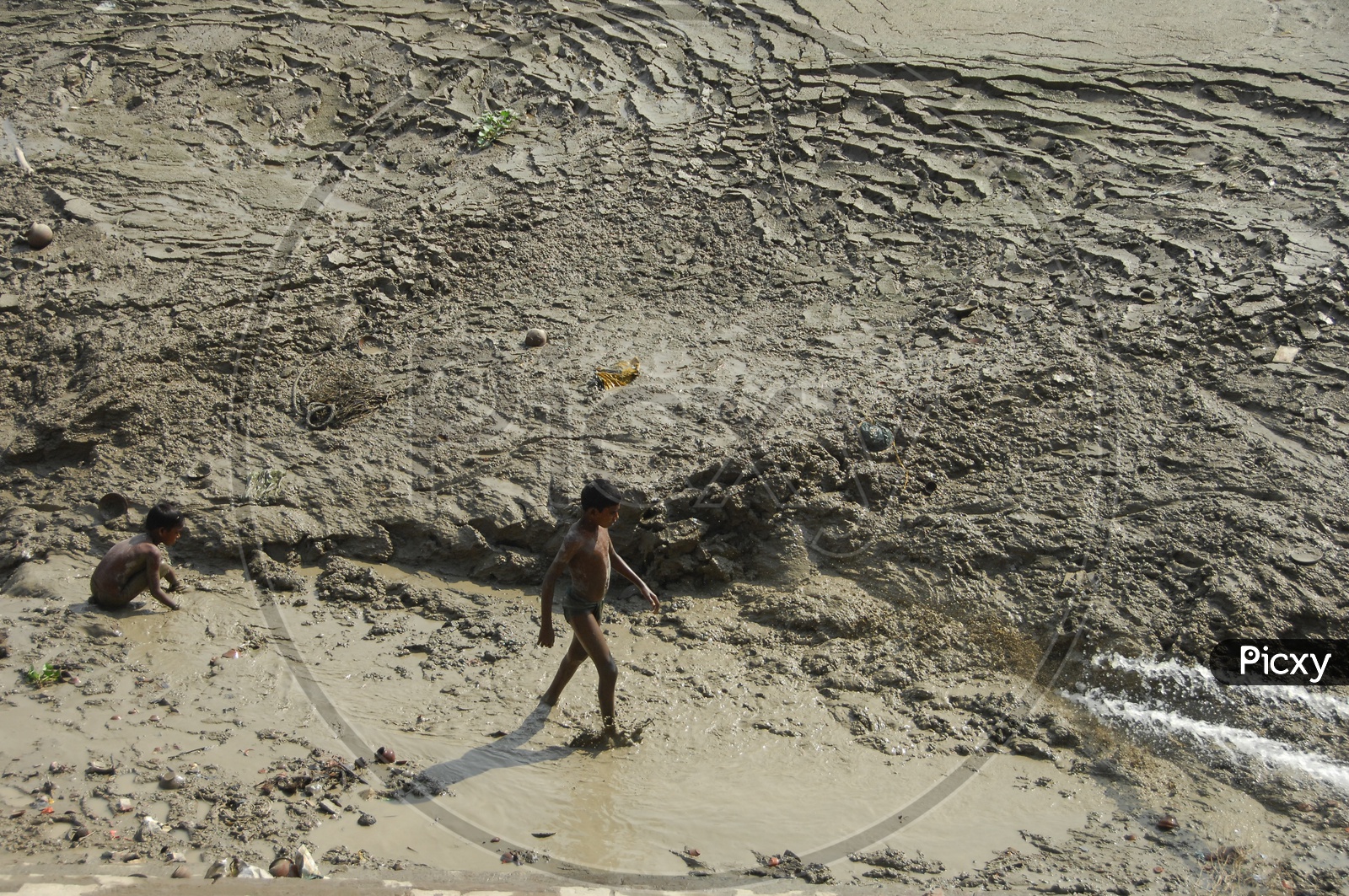 Image of Indian Boys/Kids playing in Wet Mud-JL435933-Picxy