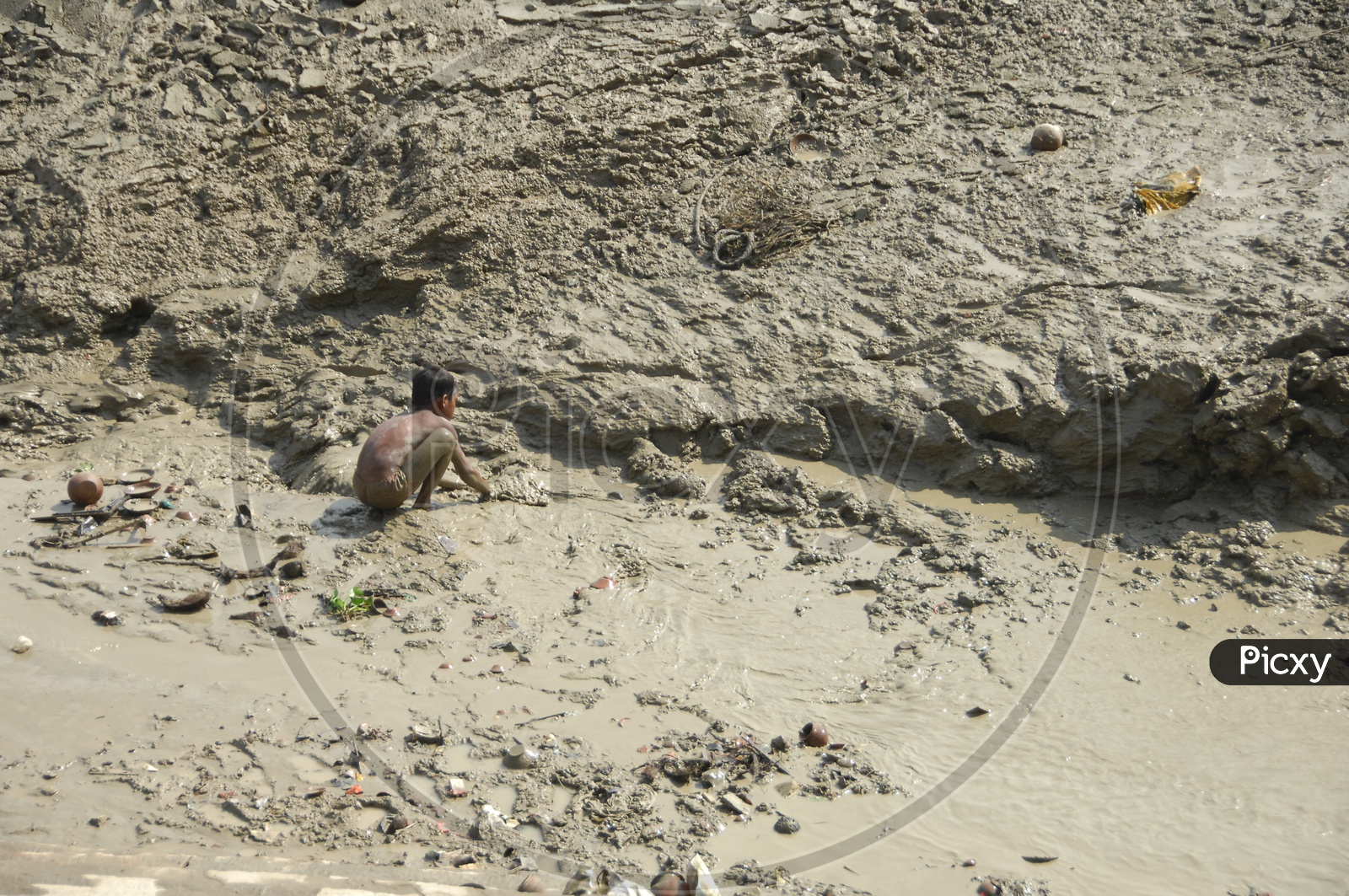 Image of Indian Boy playing in Mud-XS935478-Picxy