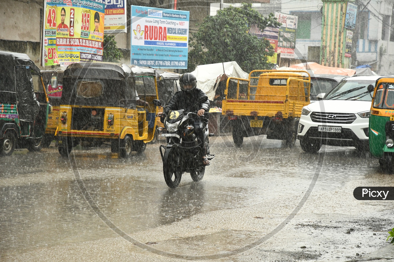 Image of Bike Commuter Riding in Rain on Urban City Roads-IZ526408-Picxy