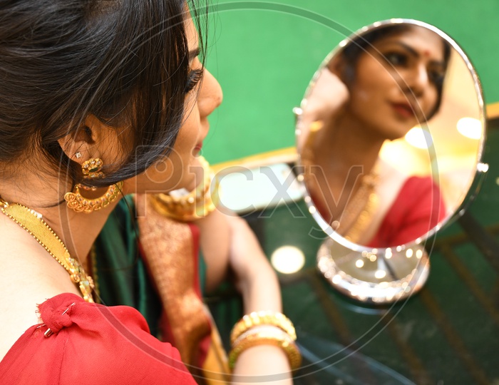 Image of Woman checking her Jewellery in Mirror-EX135472-Picxy