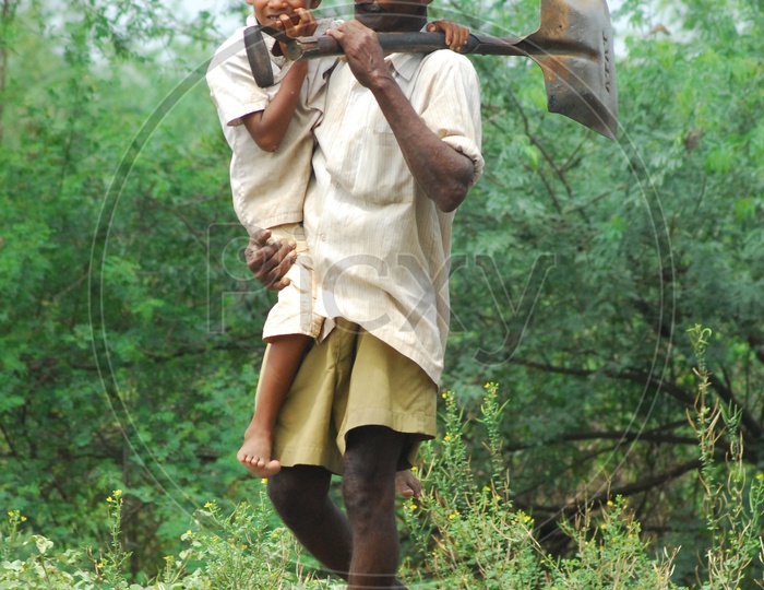 Image of Indian Farmer carrying his child-MO703463-Picxy