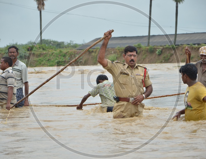 Image of Indian Men helping Old Man evacuate house during floods ...