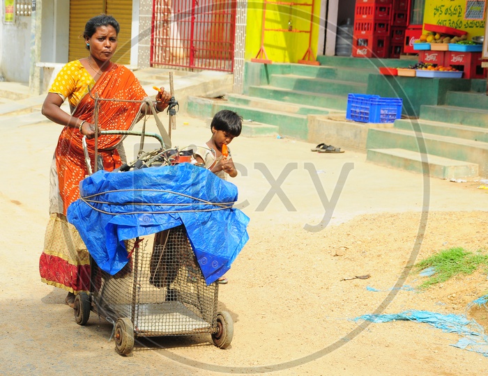 Image of Indian Woman pushing a Cage trolley-YE420633-Picxy