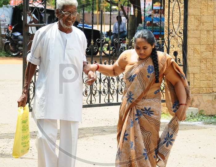 Image of Indian Old Man helping physically disabled woman walk-TA519631 ...