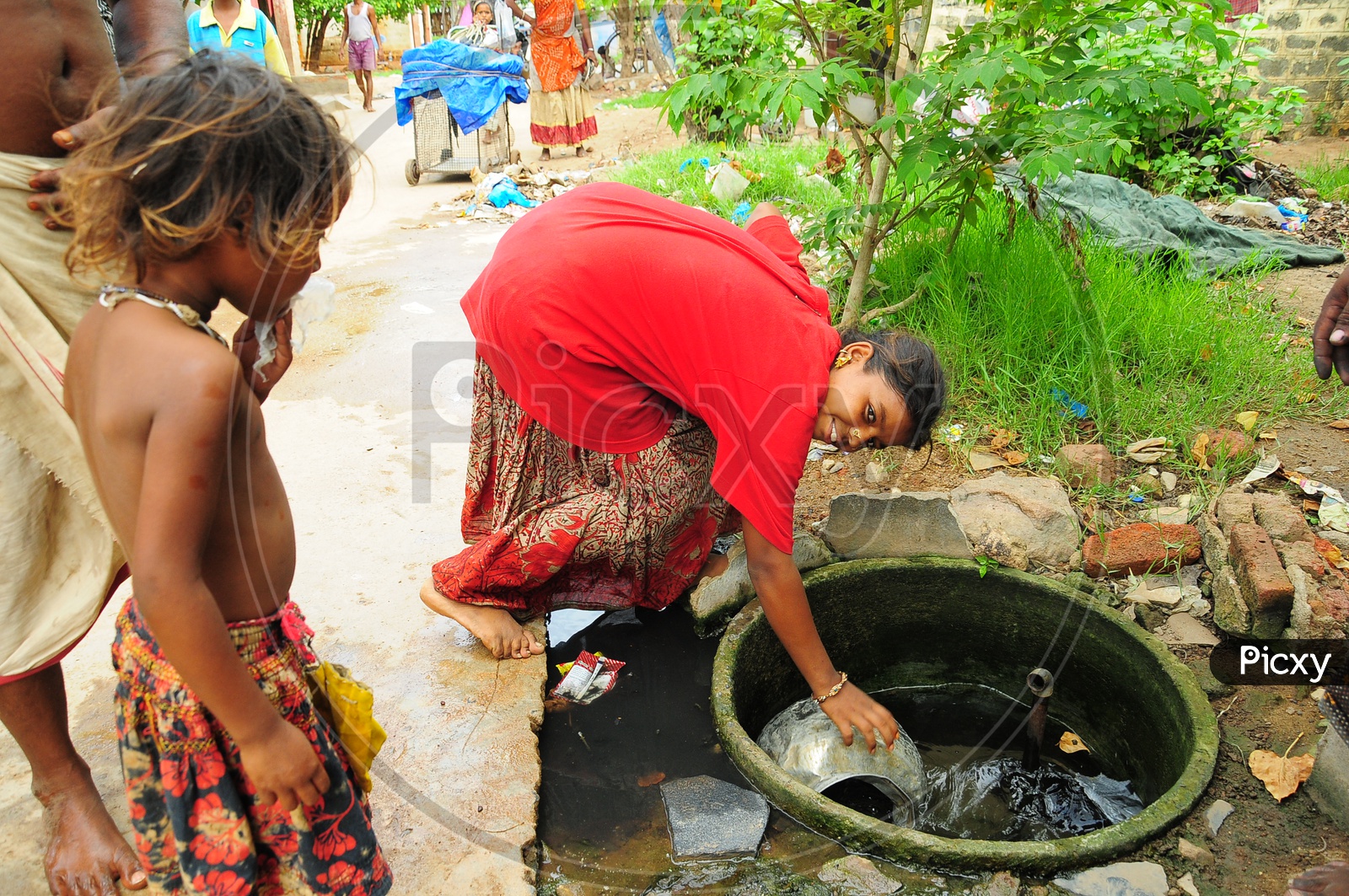 Image of Indian girl collecting water from a well-SC992318-Picxy
