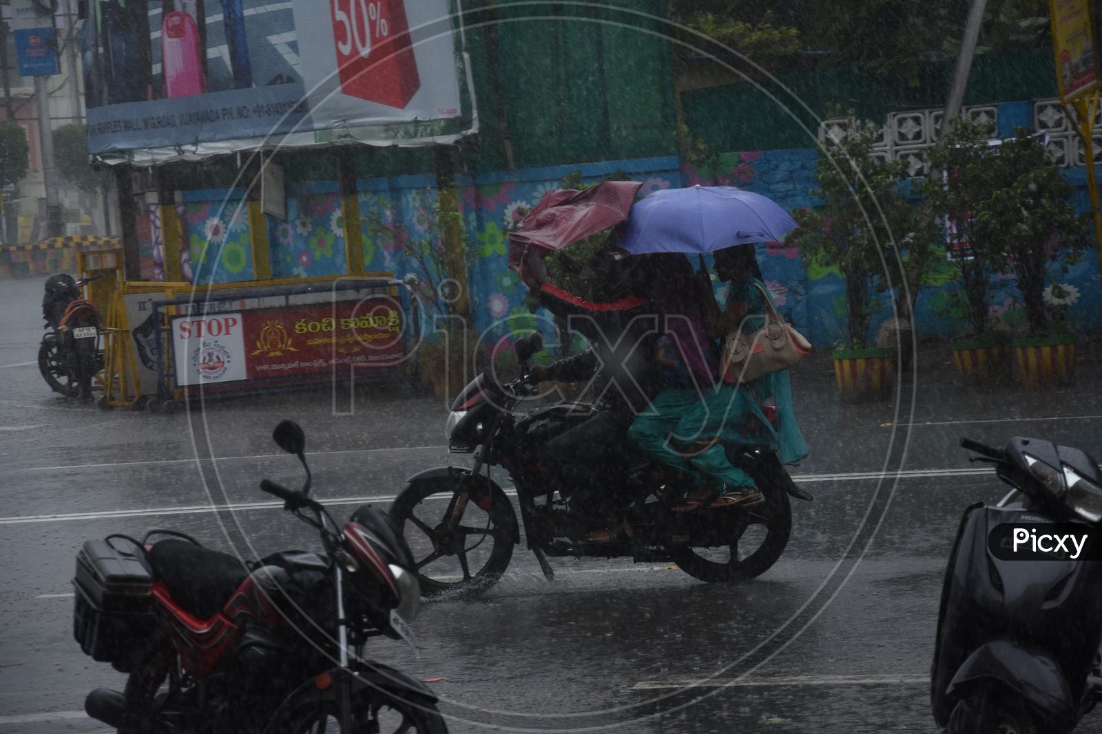Image of Triple Riding on Bike in Rain-ST221464-Picxy