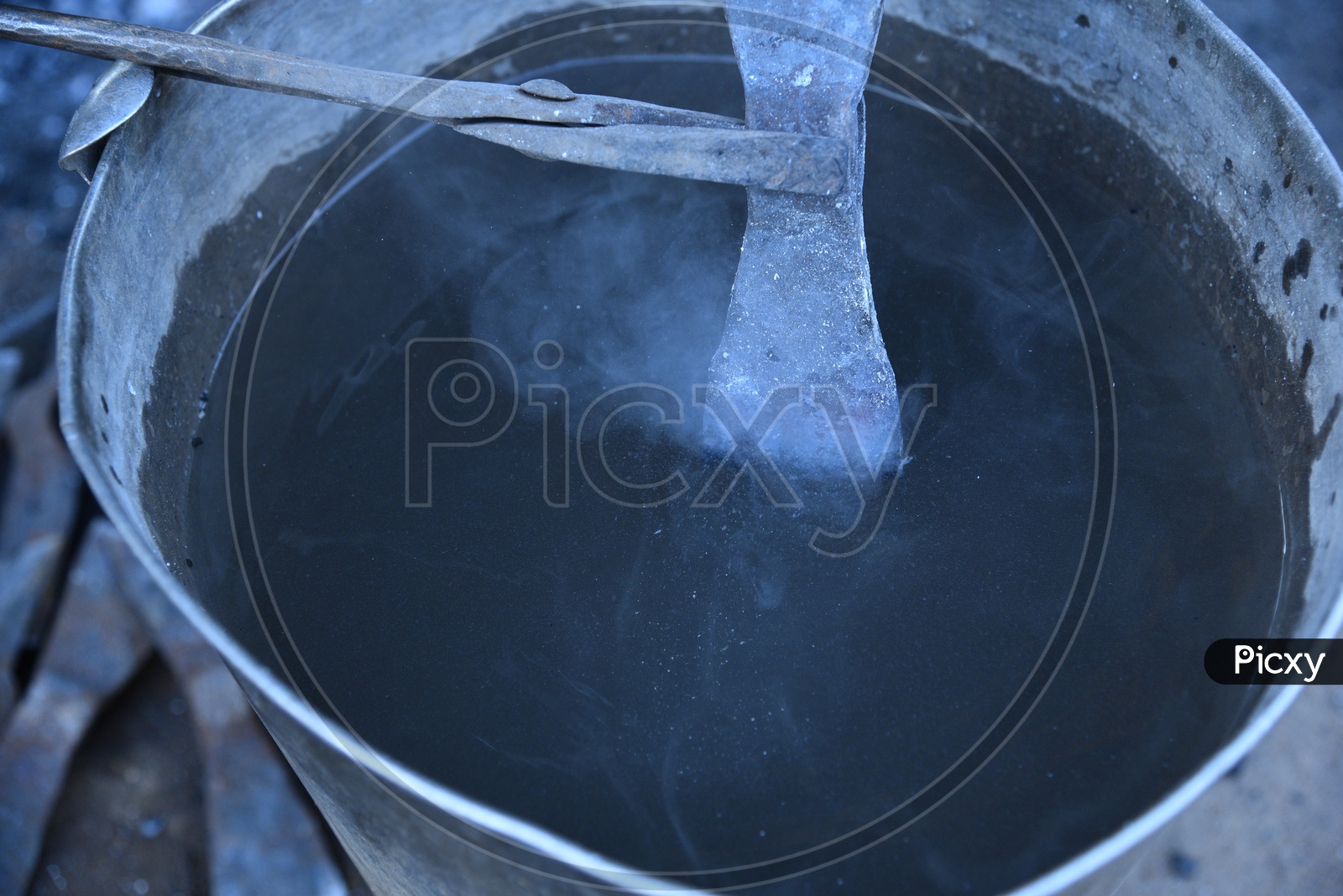 Image of Blacksmith Cooling Hot Metal in Water-MH687975-Picxy