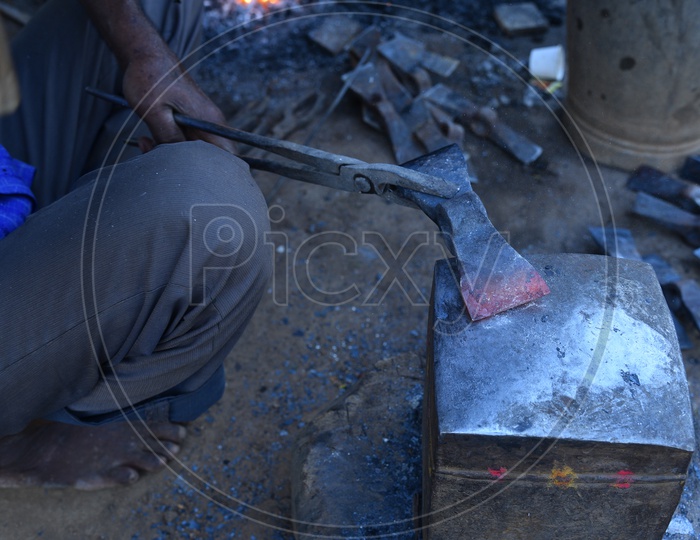 Image of Indian Blacksmith Shaping the Hot Metal using Hammer-YD694492 ...
