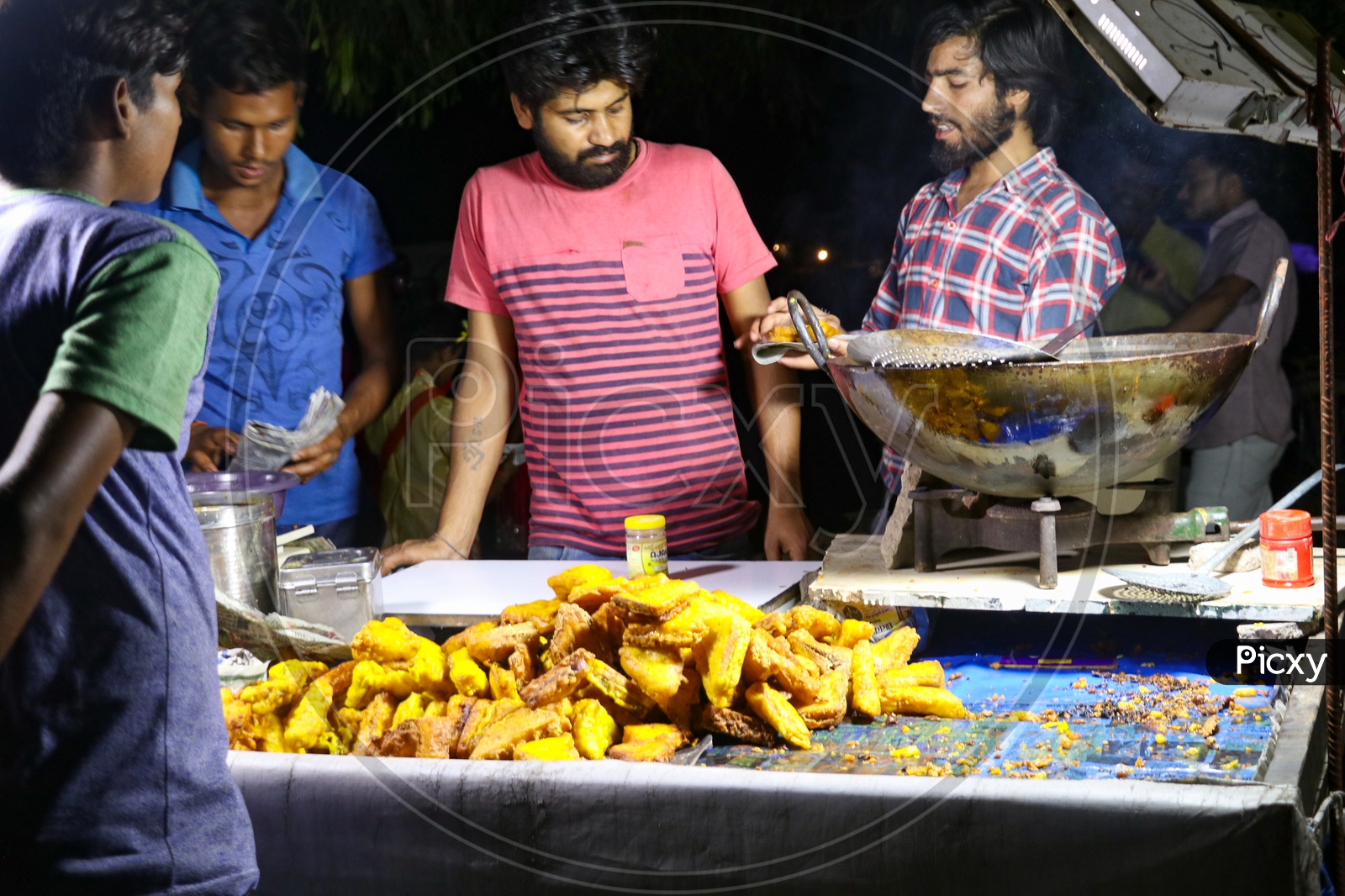 Image of Street vendor selling bread Pakodas in a night market-LB886075 ...
