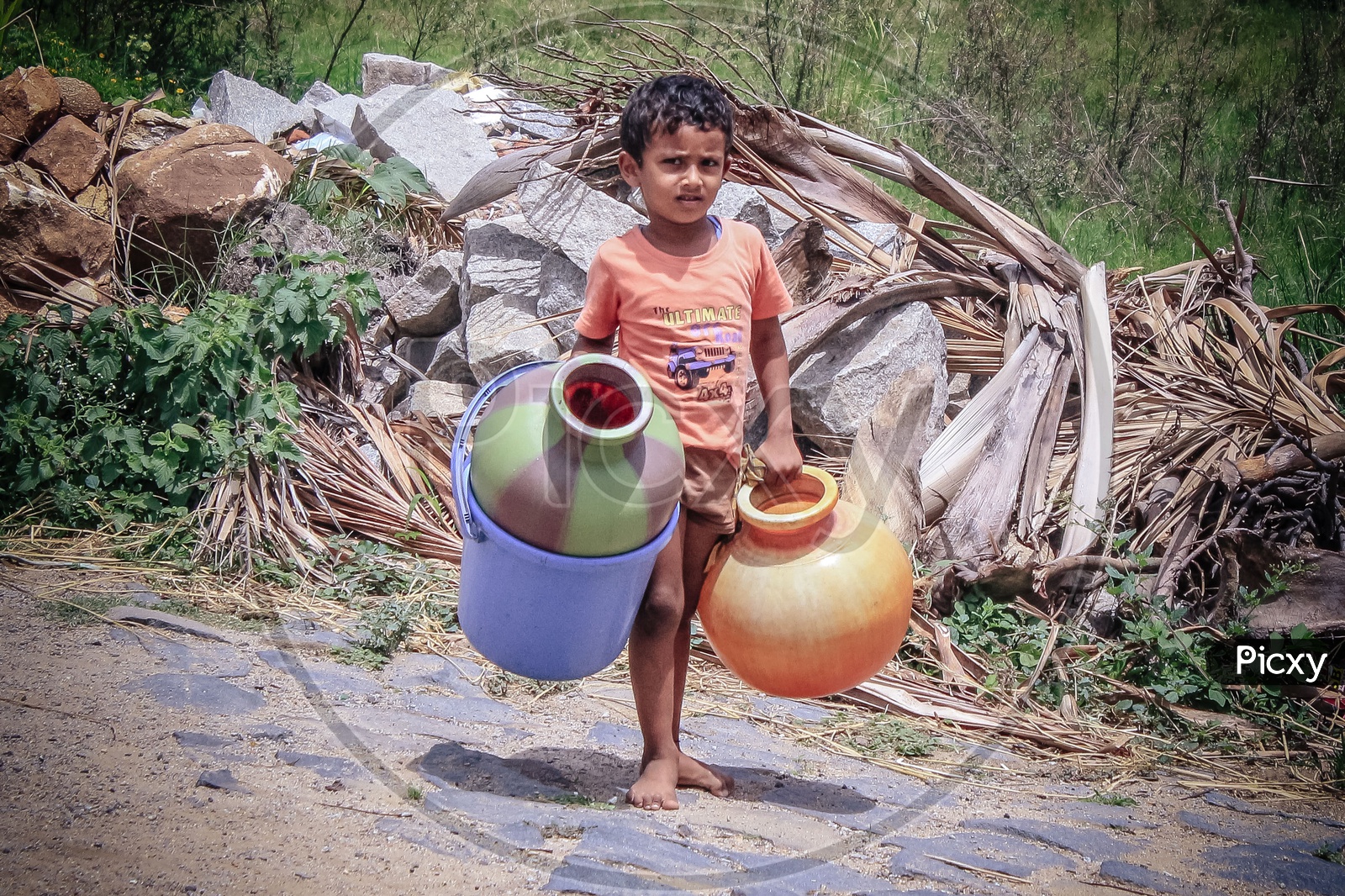 Image of A child carrying plastic buckets and plastic pots-XK234391-Picxy