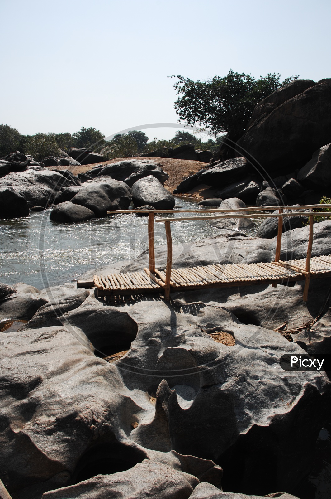 Image of Log footbridge on the rocks over the river-AU862039-Picxy