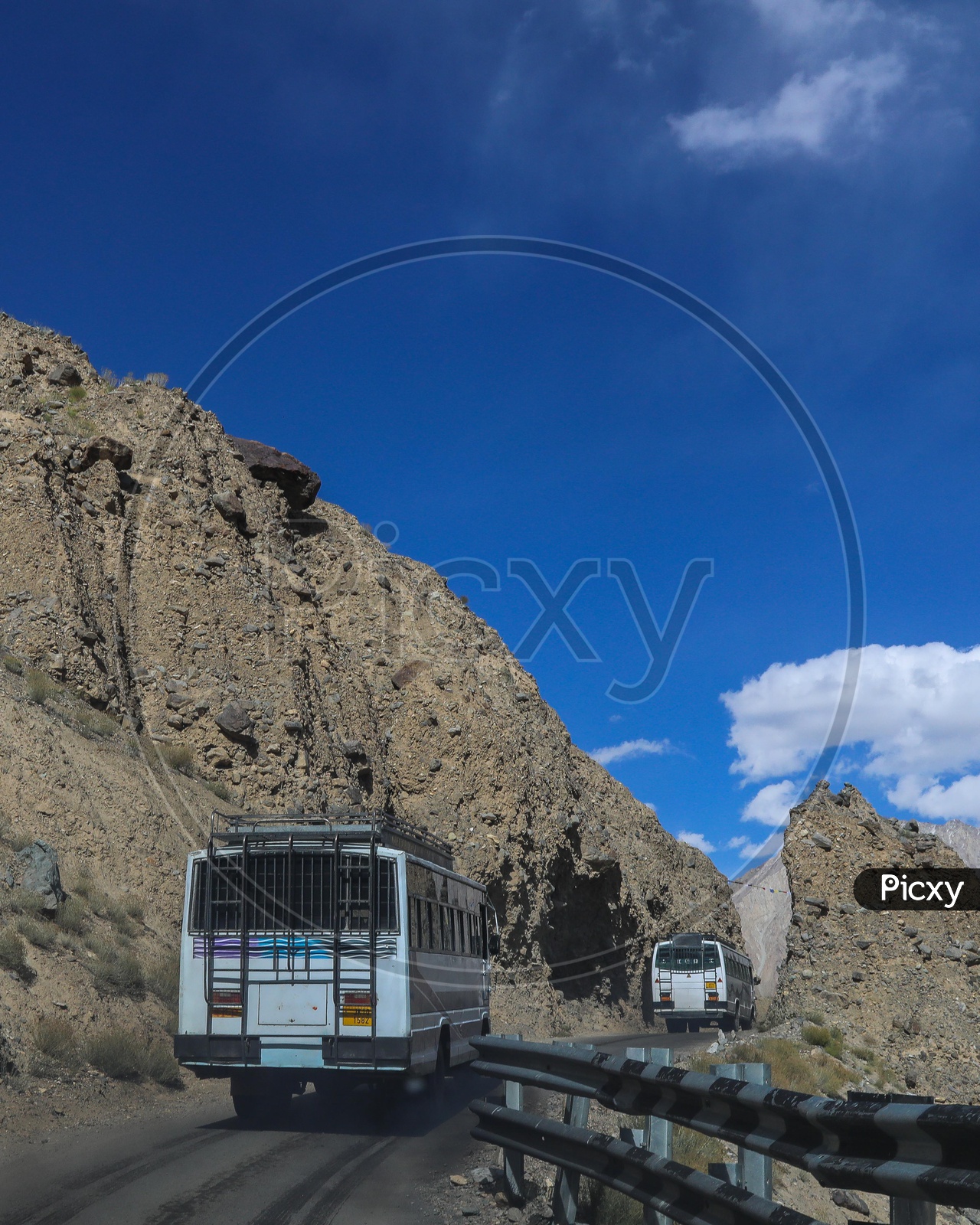 Image of Buses though the roadway by the mountains-FS676540-Picxy