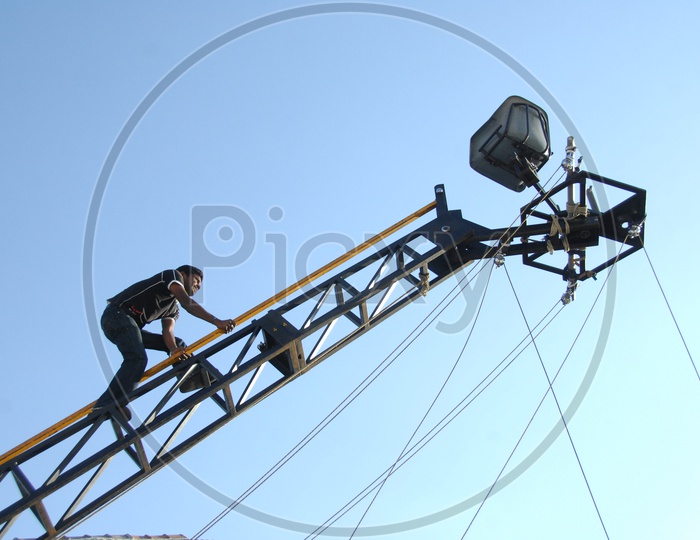 Image of Man crawling along the crane tower to take the seat-EZ930394-Picxy