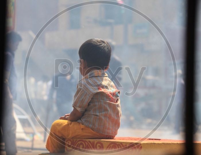 Image of A Lone Child Sitting on a Street-OG494170-Picxy