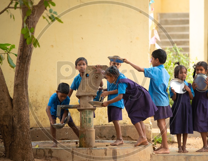 Image of Primary school students washing their plates after the mid day ...
