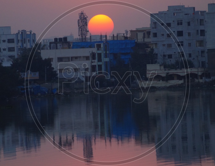 Image of Sunrise over buildings at Saroornagar lake-KA556533-Picxy