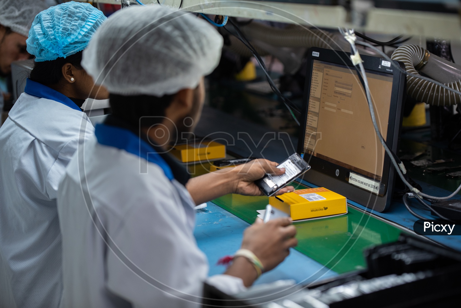 Image of Technicians Assembling Mobile Parts Manually In a Mobile ...
