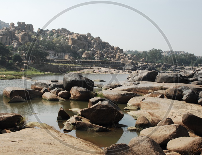 Image of Hampi temple ruins in between the mountain rocks and lake ...