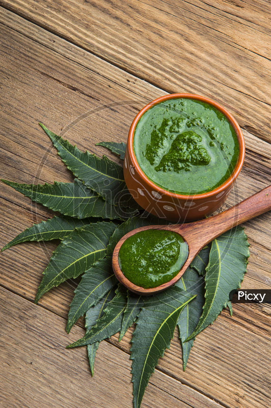 Image of Medicinal Neem leaves with paste on wooden background-NI432669 ...