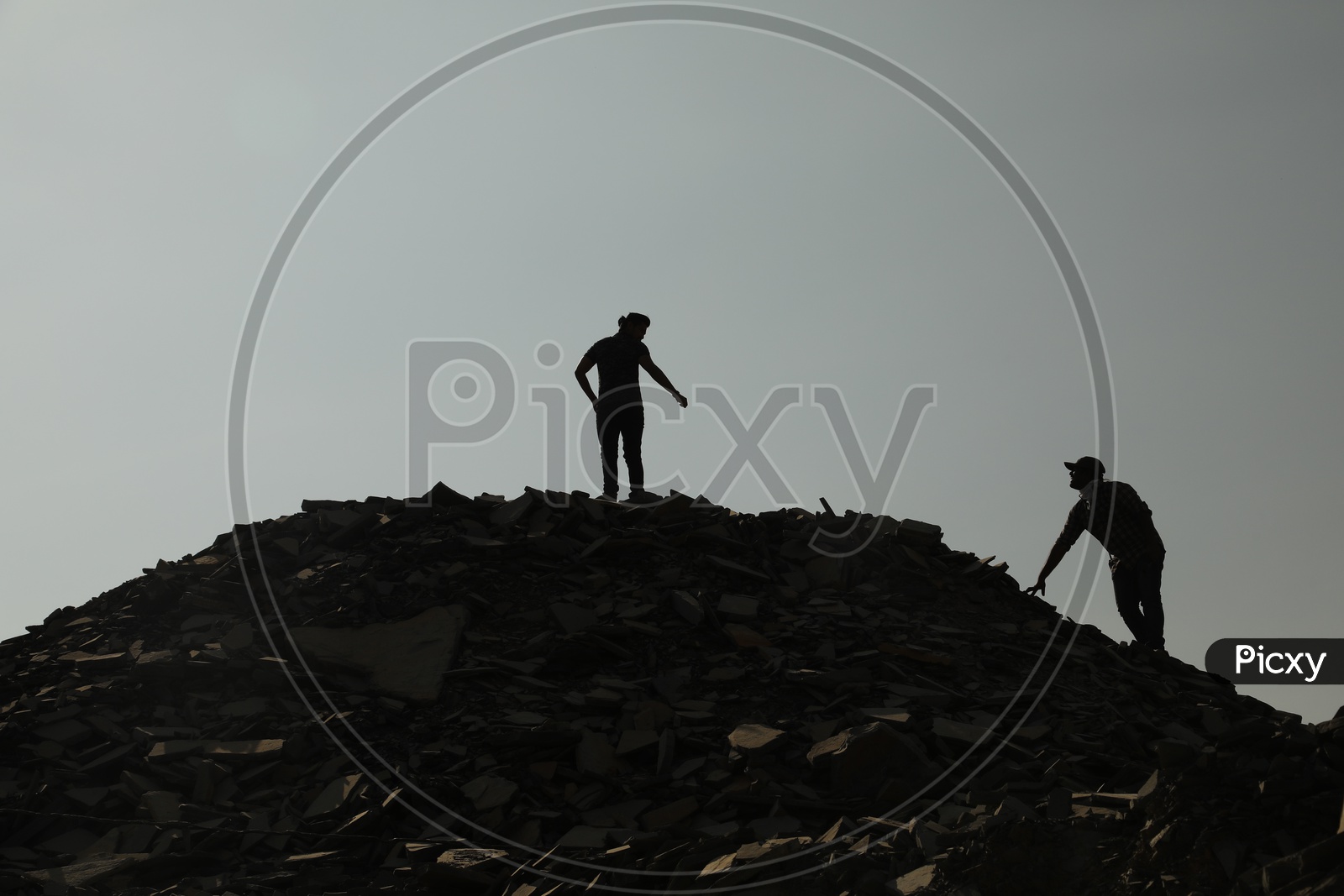 Image of Silhouette of 2 men on the top of the Black stone mining area ...