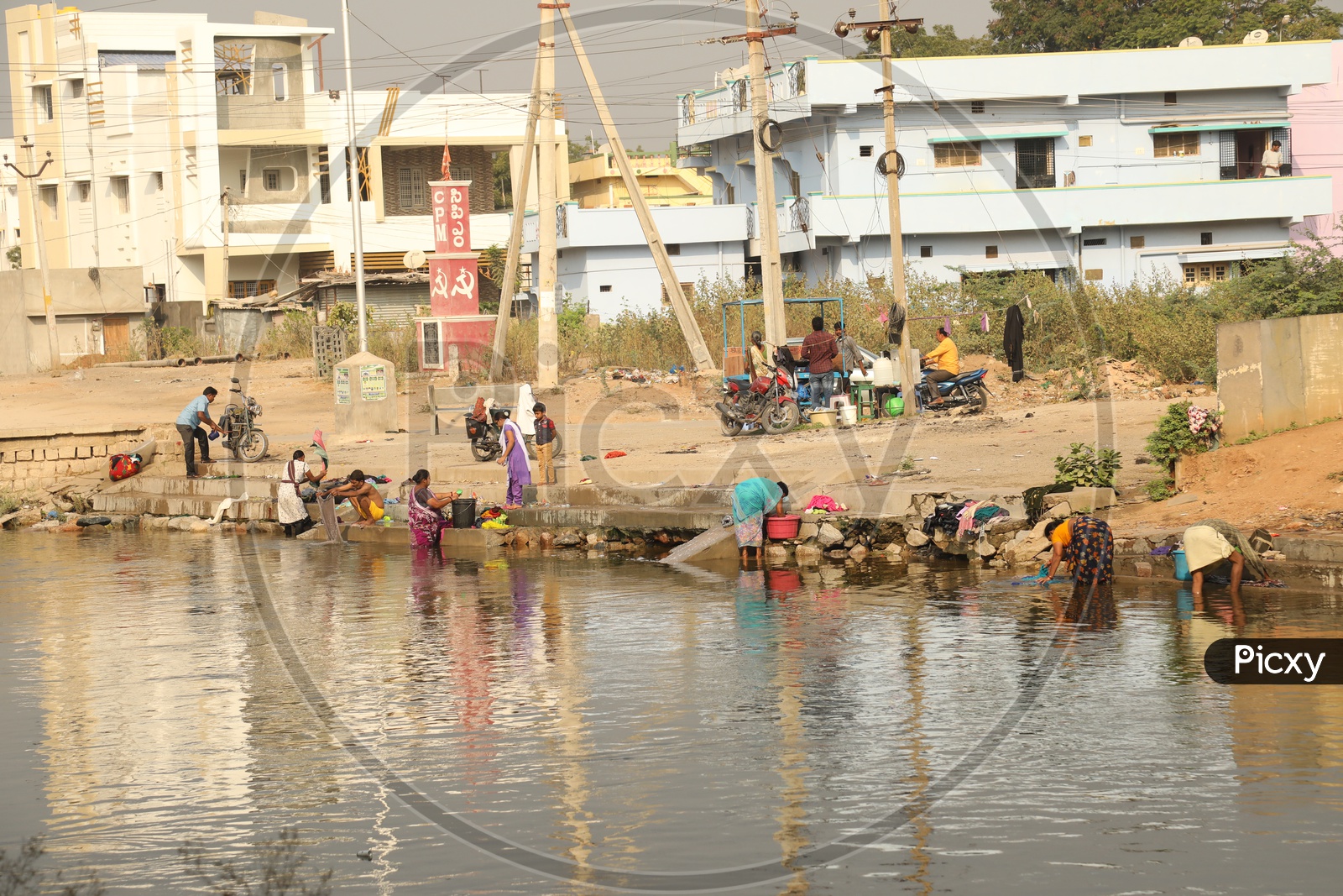 Image of People washing clothes near a pond-ZC626825-Picxy