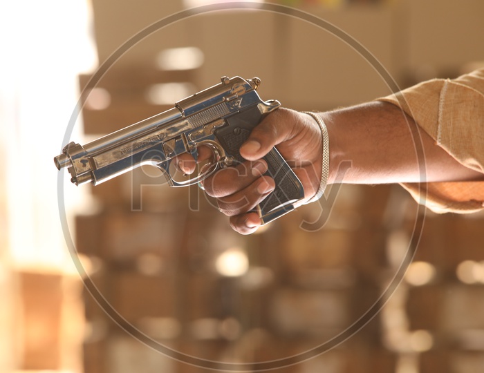Image of Hand of a man holding a soft gun-FE955716-Picxy