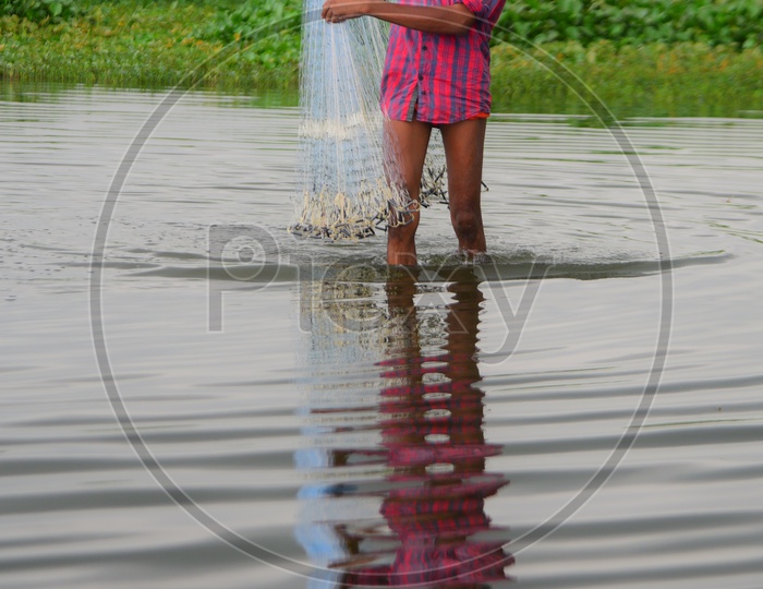 Image of A man with the fishing net ready to cast it-SZ717397-Picxy