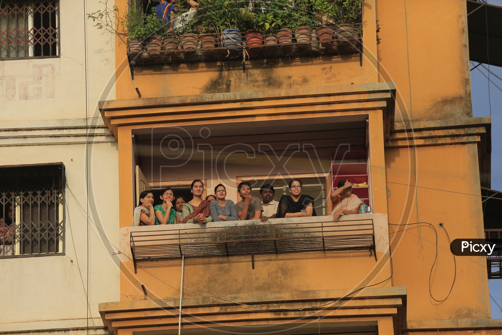 Image of People looking out from a balcony of a house-TK800974-Picxy