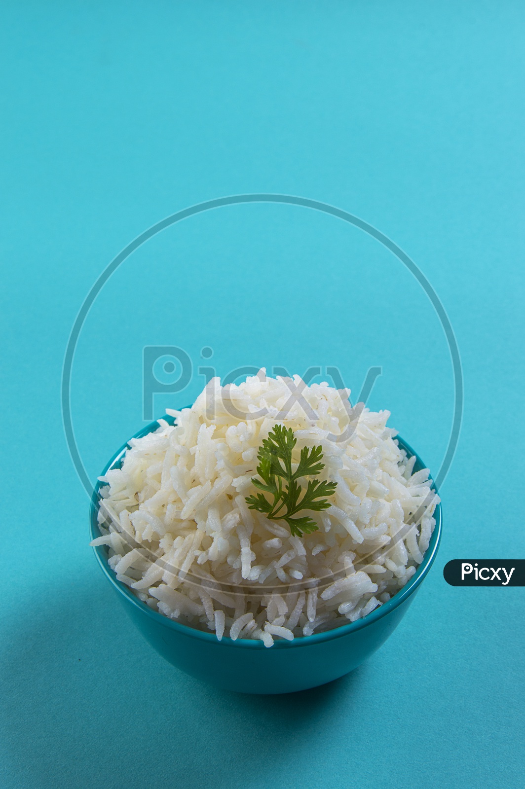 Image of Cooked plain white basmati rice with corriander in a blue bowl ...