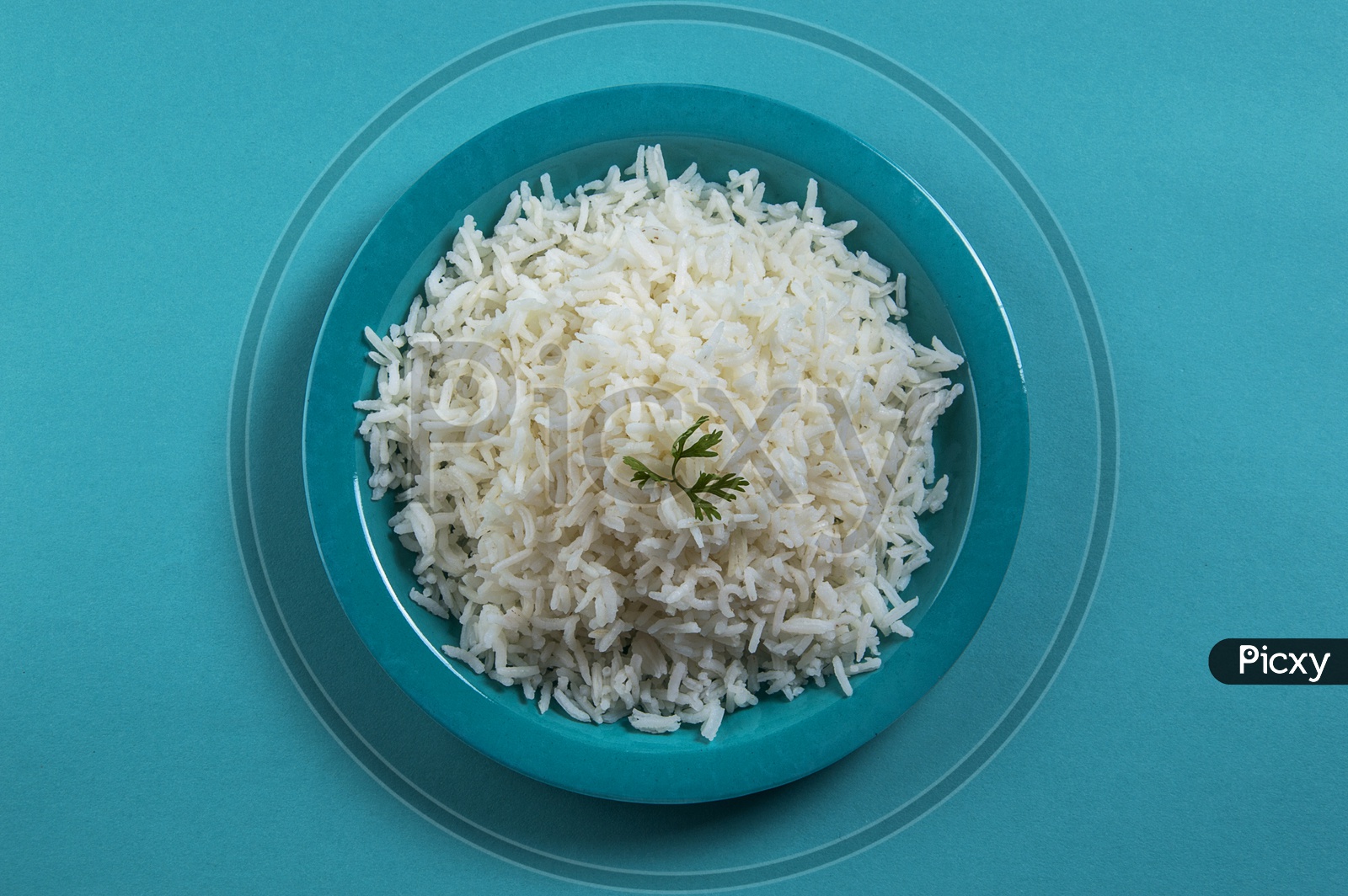 Image of Cooked plain white basmati rice with coriander in a blue plate ...