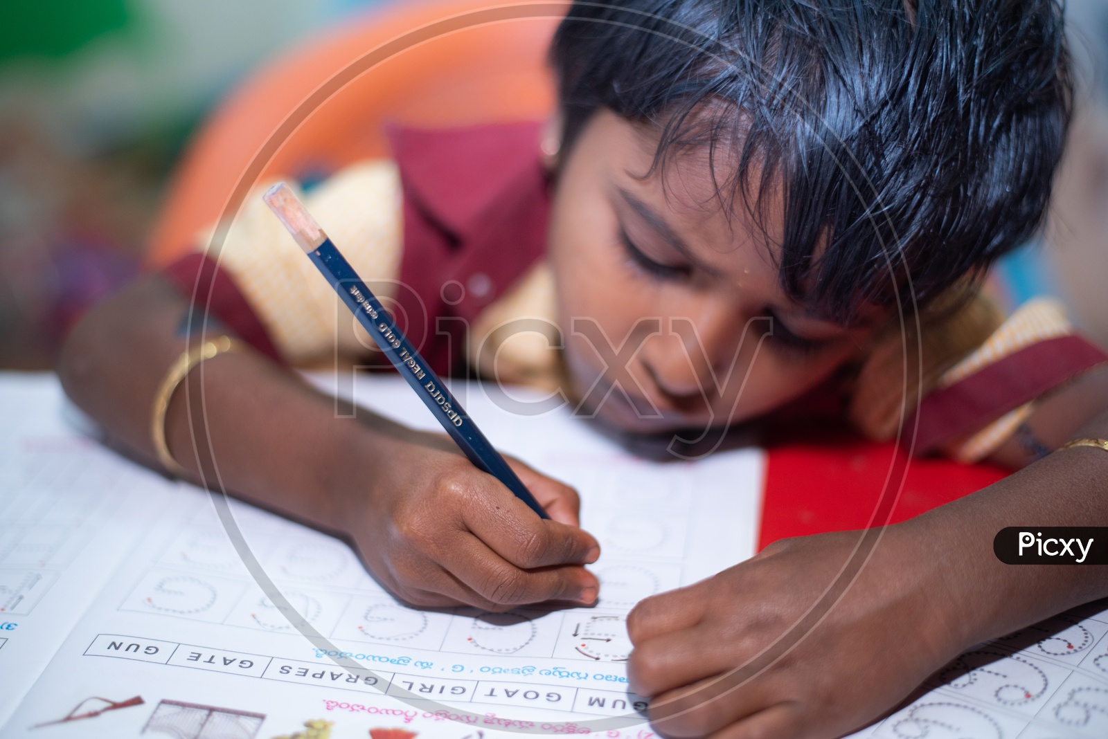 Image of Student writing on a book at an Anganwadi center-ZF356940-Picxy
