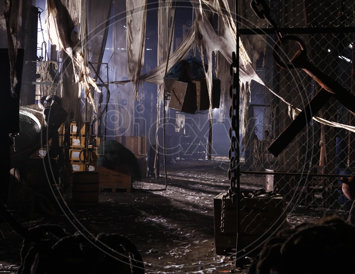 Image of Plastic drums, old cars and litter in an old factory godown ...