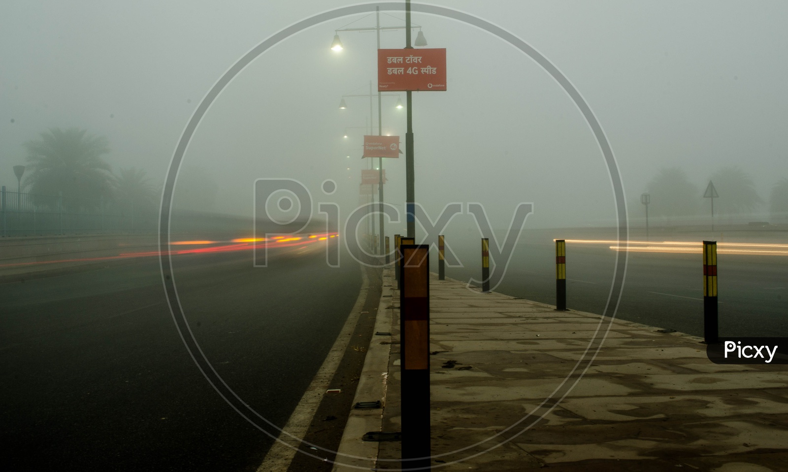 Image of A Pathway On a Road Divider With Railing Poles-WO799180-Picxy