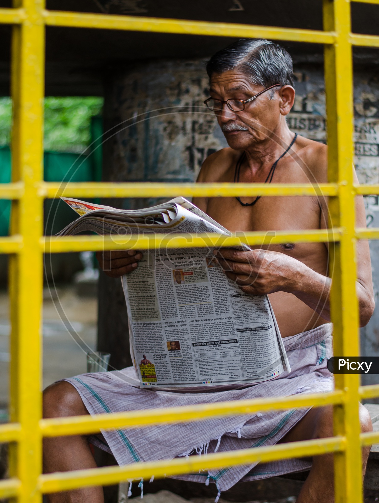 Image of An Indian Rural Man Reading Newspaper-KF803034-Picxy