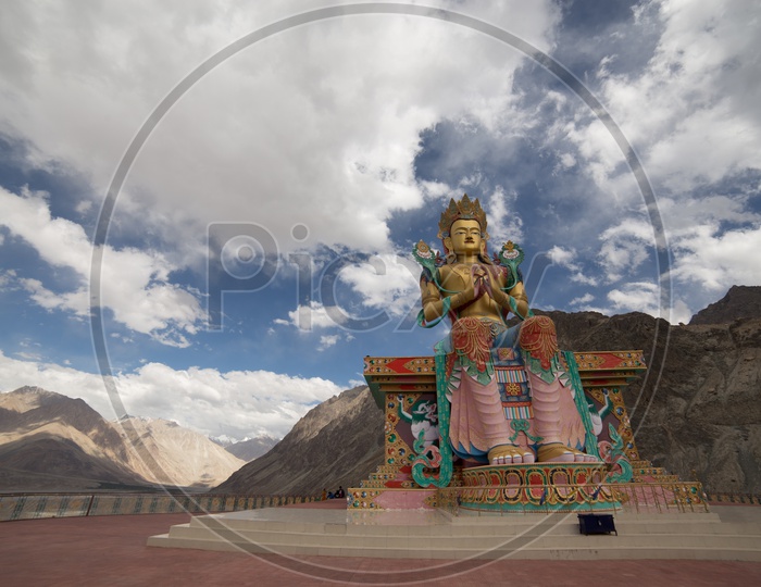 Image of Statue of Buddha in leh with snow capped mountains in the ...