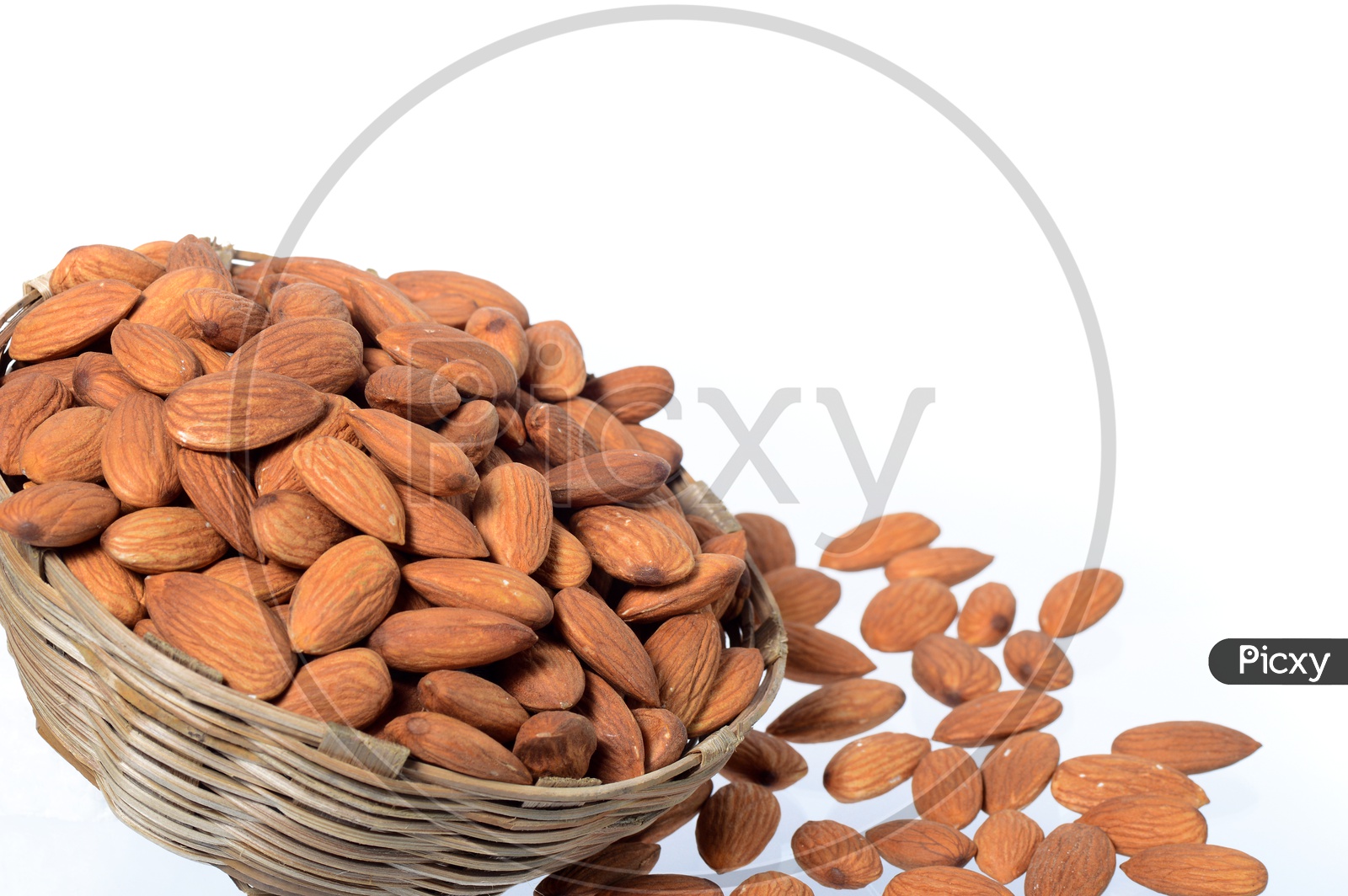 Image of Almonds Or Badam Nuts Heap On a Wooden Weaved Bowl On An ...