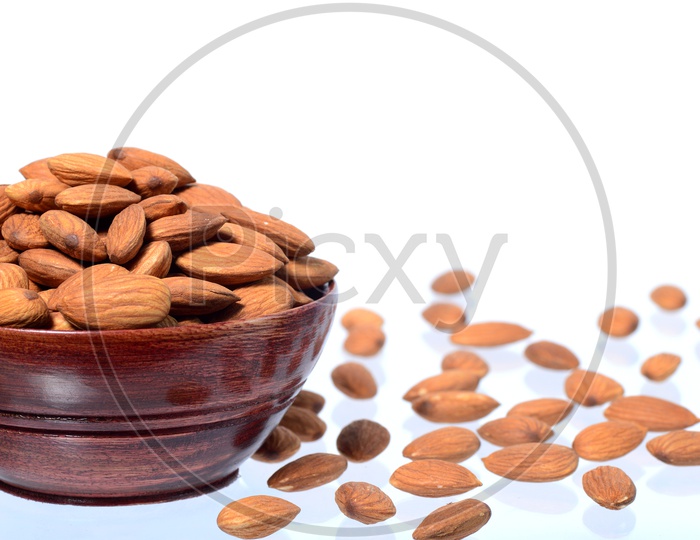 Image of Almonds Or Badam Nuts Heap On a Wooden Weaved Bowl On An ...